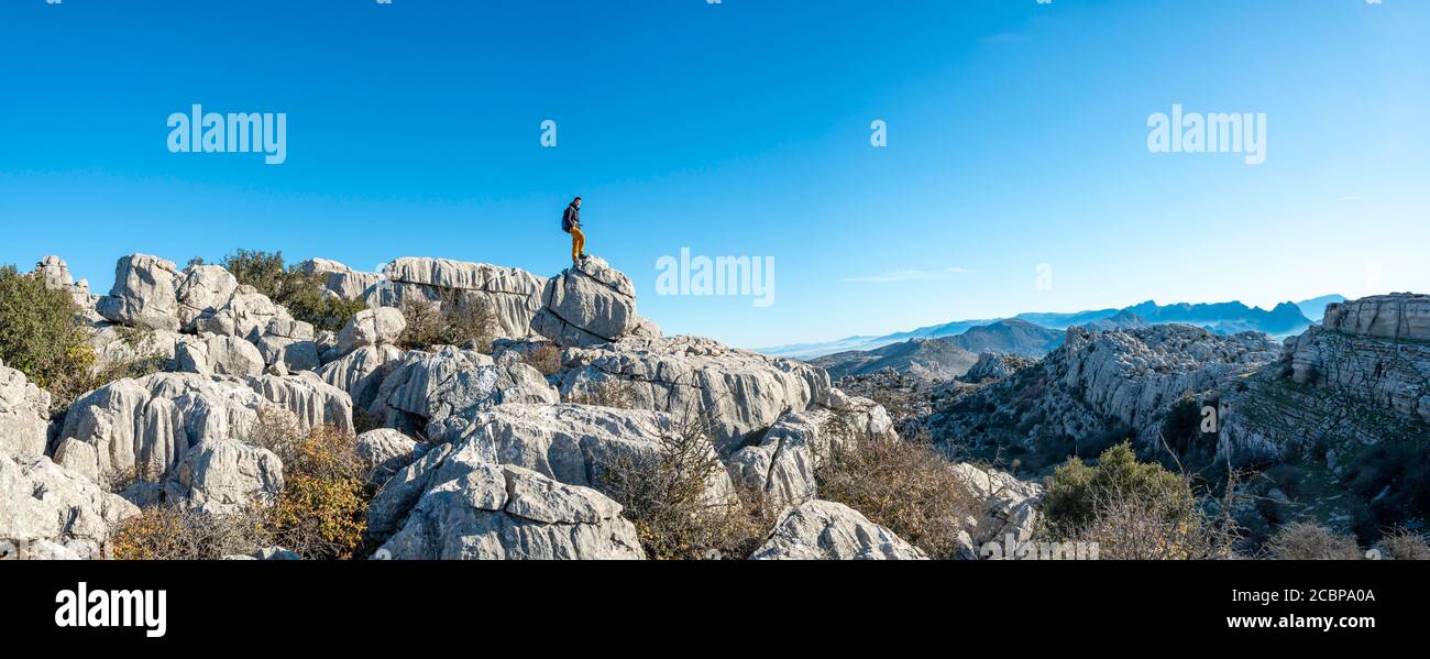 Young man standing on rocks and looking into the distance hi-res stock ...