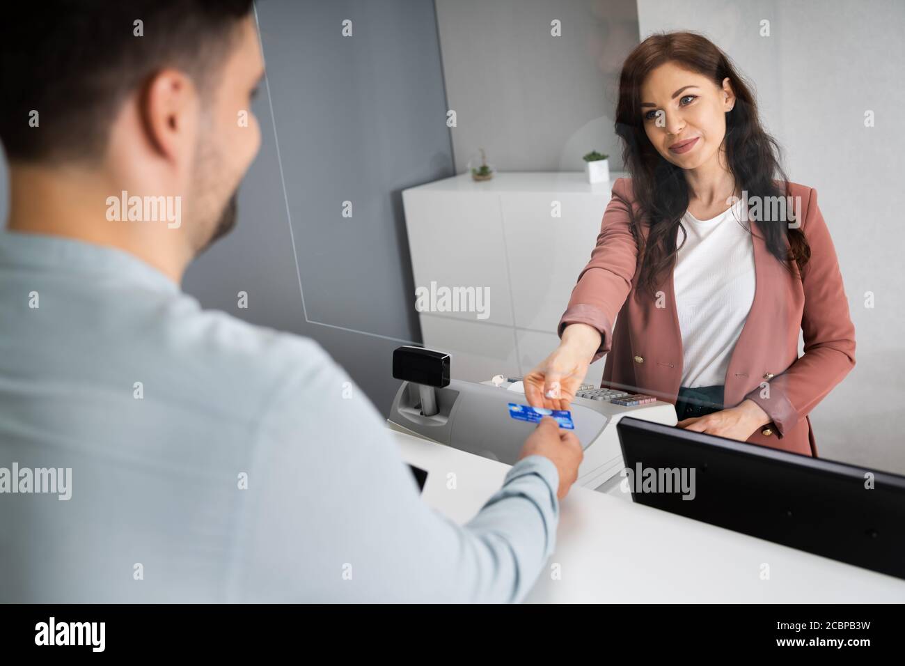 Shop Cashier In Store Or Hotel Reception Taking Credit Card Stock Photo ...