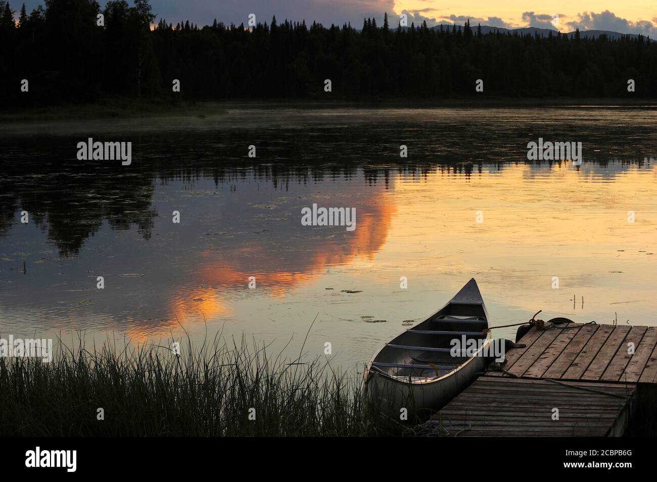 Canoe in the evening mood at the jetty of lake hi-res stock photography ...