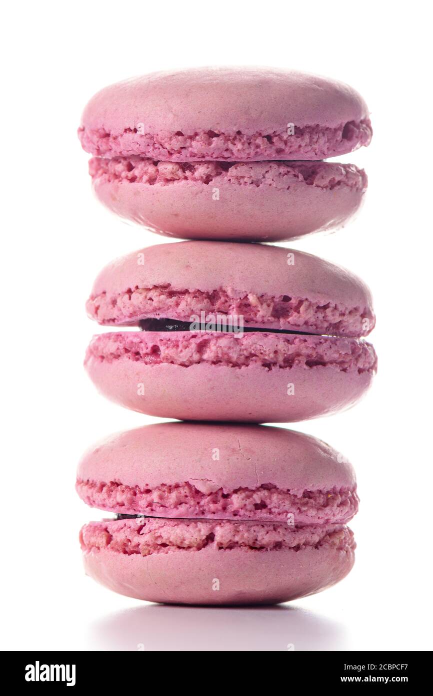 Three raspberry flavoured macaroons standing on top of each other on ...
