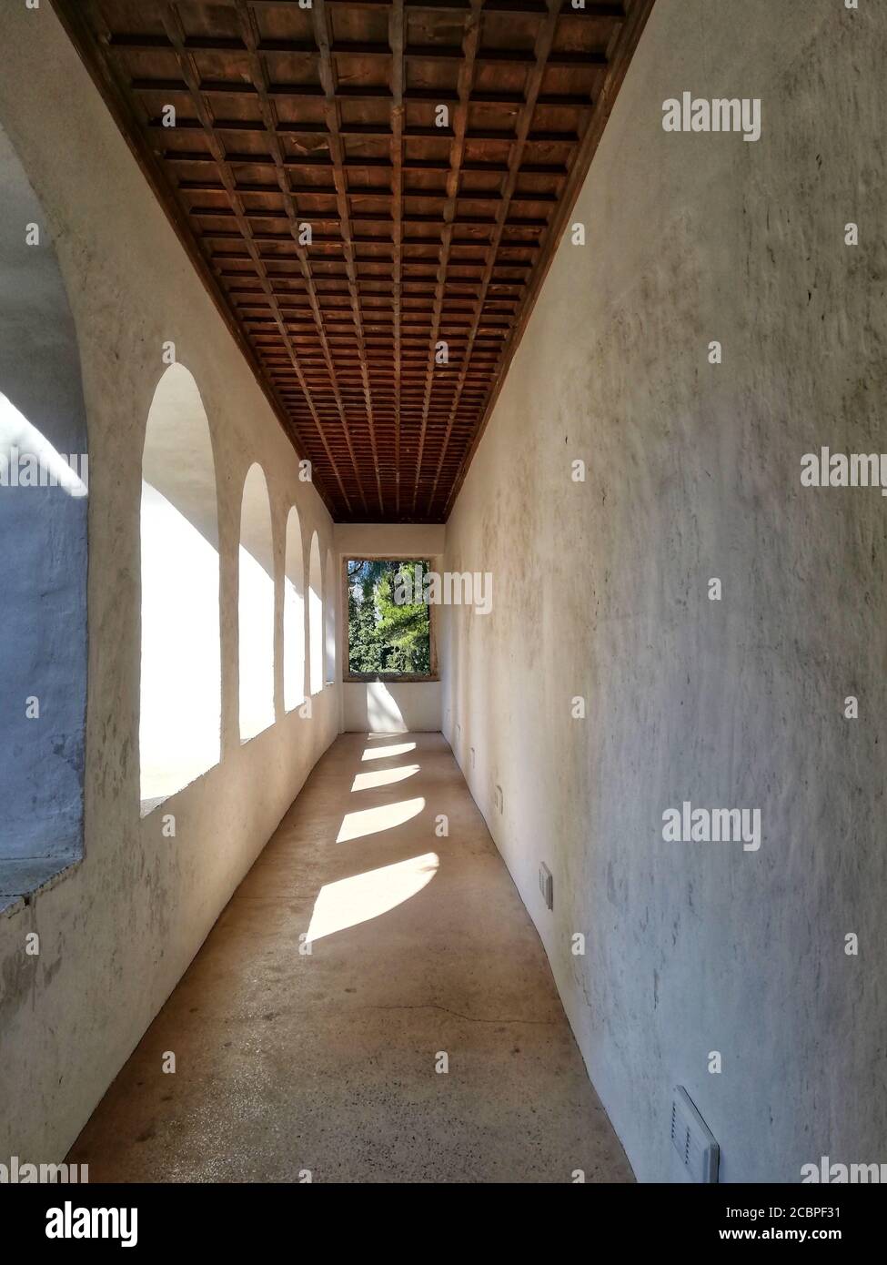 Vertical shot of a long stone balcony with structural shadows falling ...