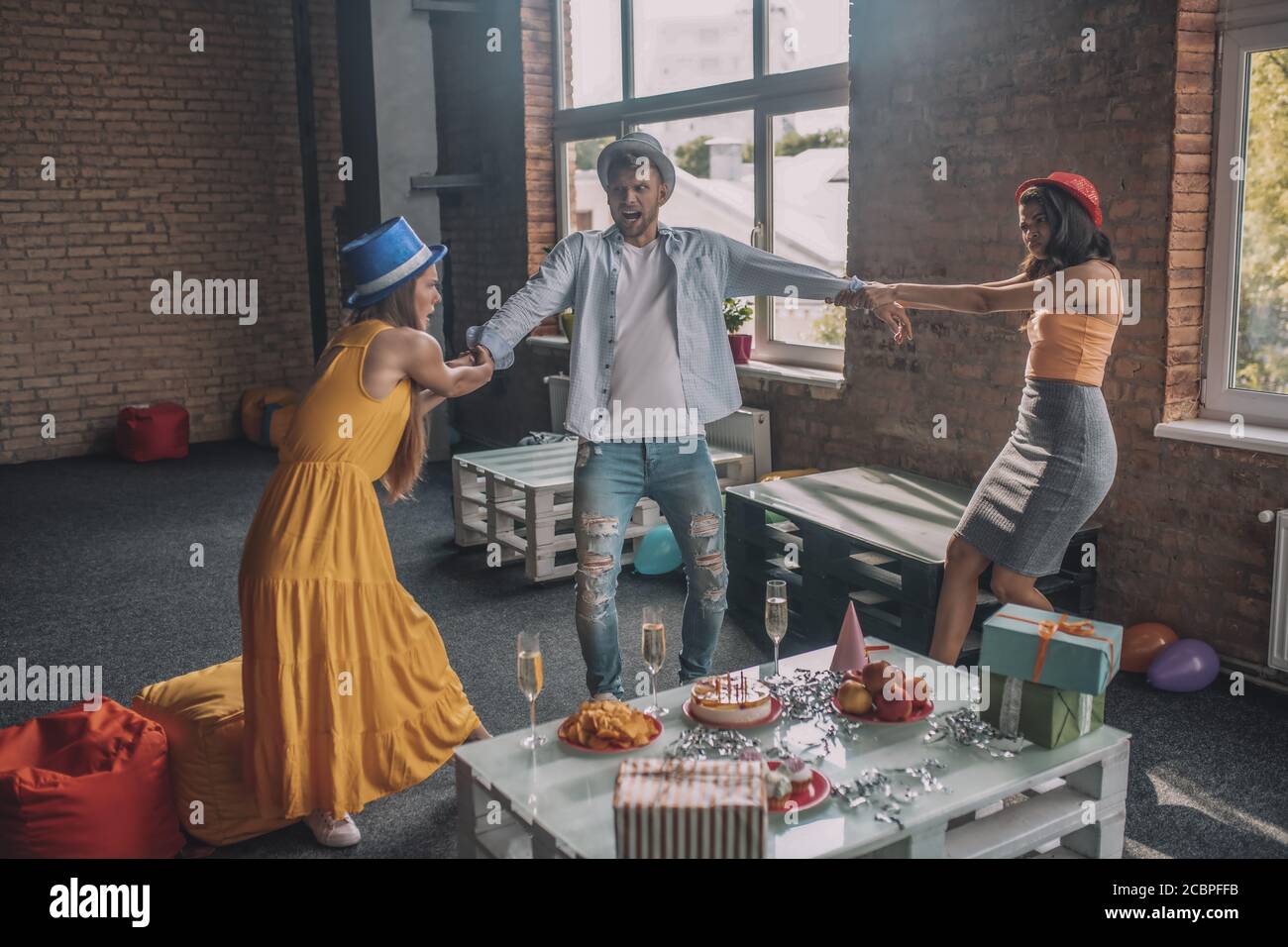 Three friends fooling around at the home party Stock Photo - Alamy