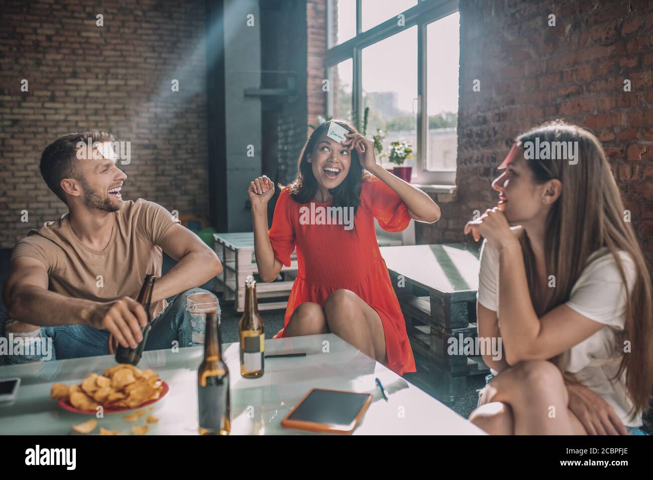 Group of friends playing a game with sticky notes Stock Photo - Alamy