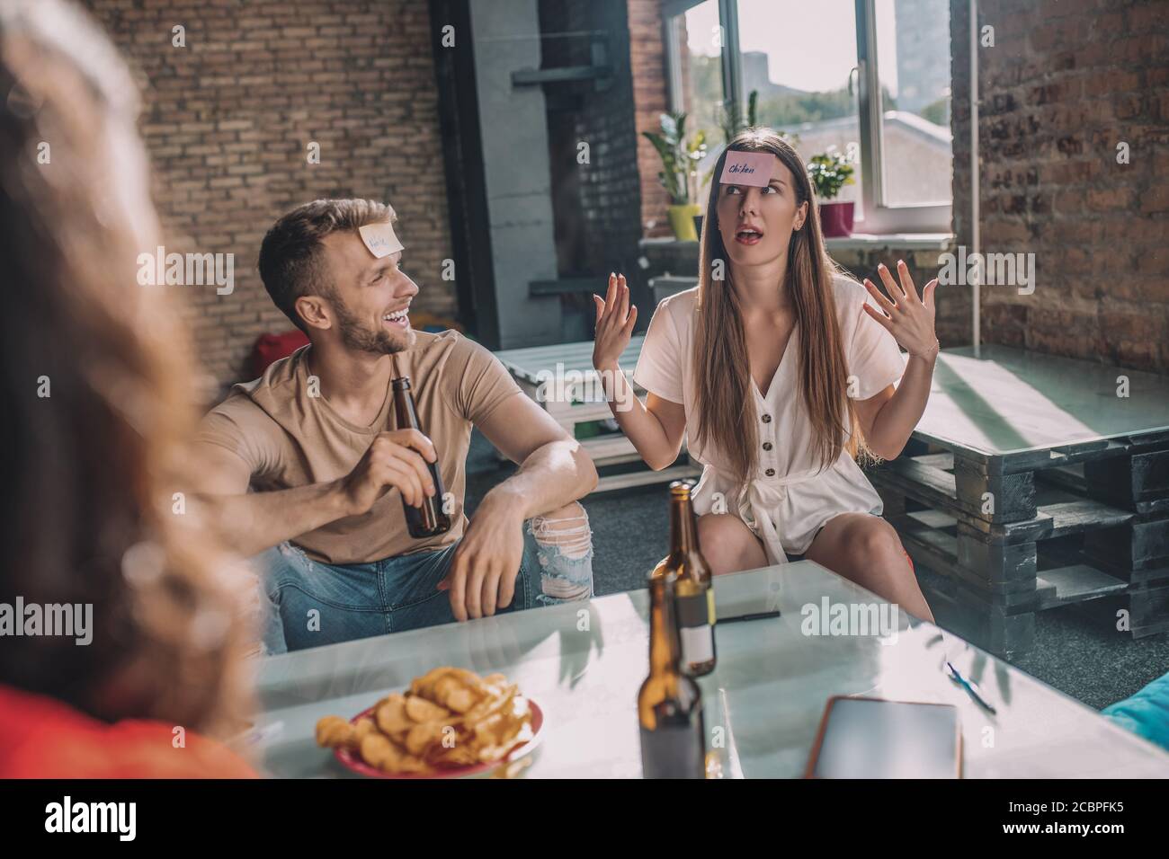 Woman trying to guess a word on her forehead Stock Photo - Alamy