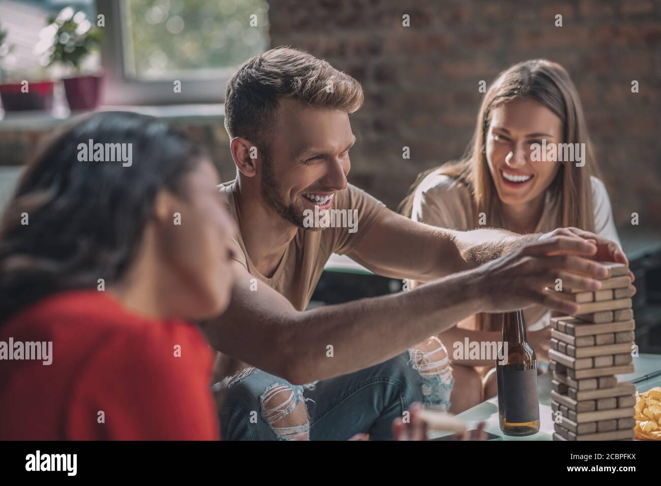 Involved man playing Jenga with his friends Stock Photo - Alamy