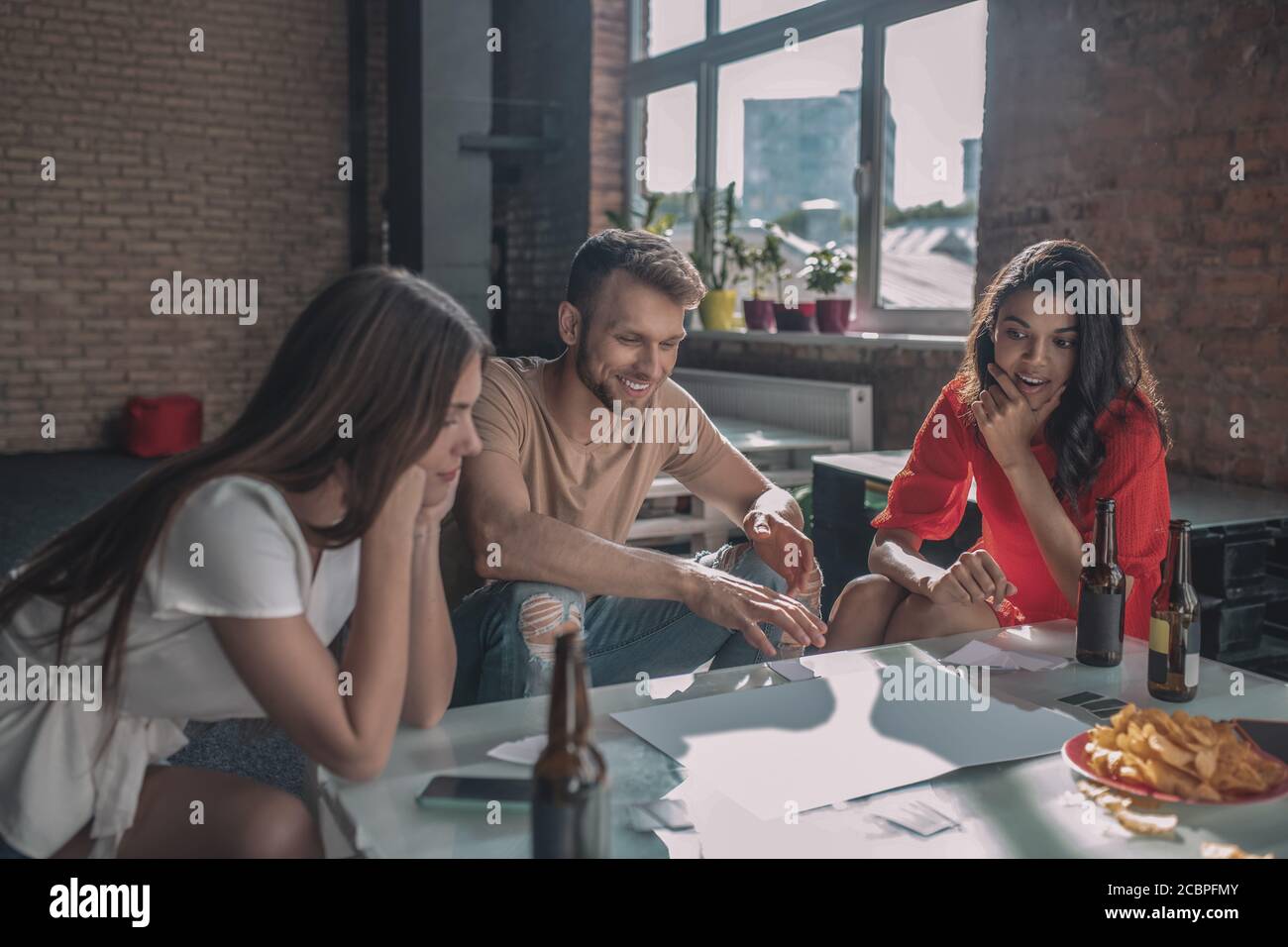Interested friends playing a sophisticated board game Stock Photo - Alamy