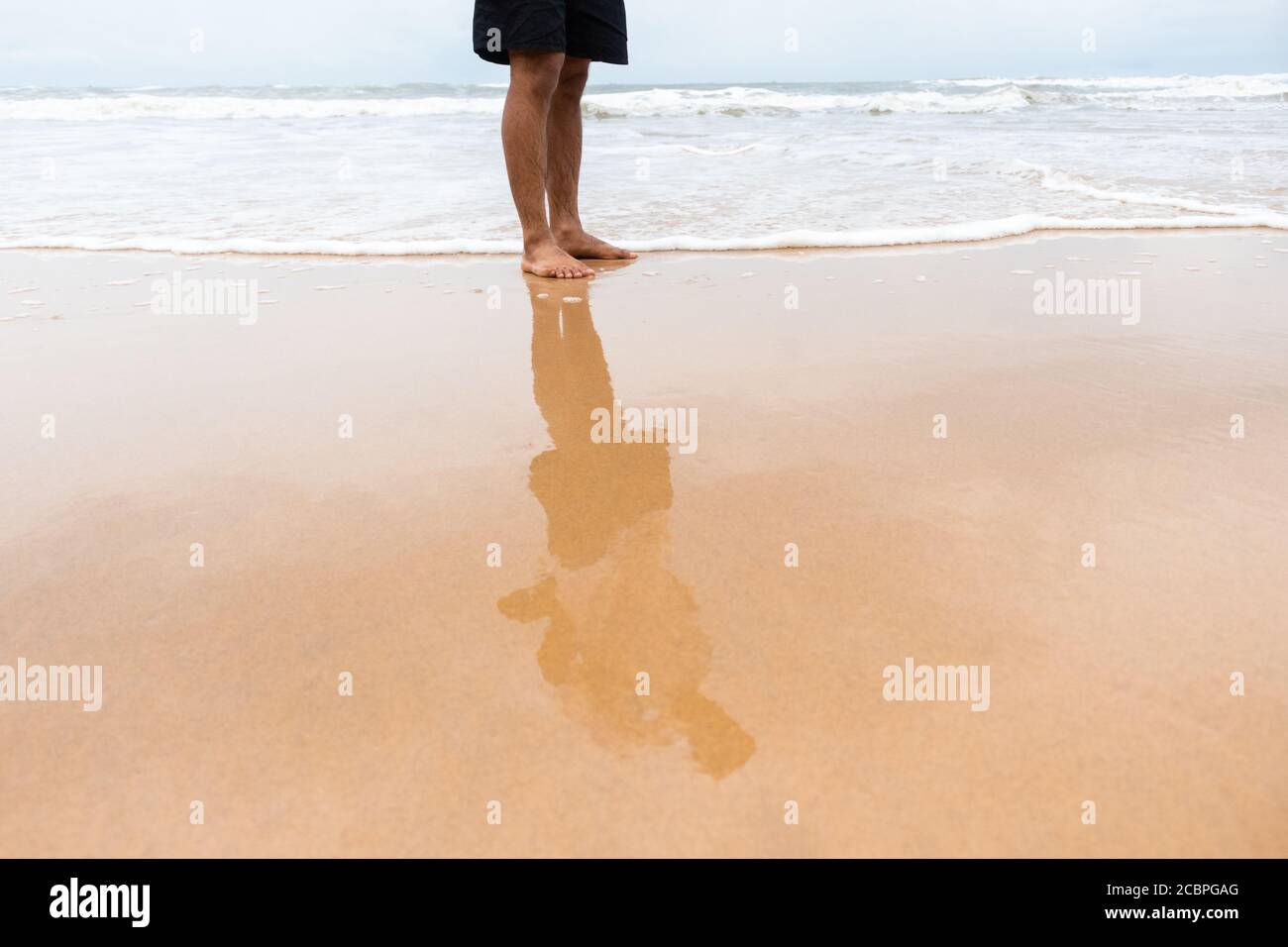 Male walking on smooth sand at the beach Stock Photo - Alamy