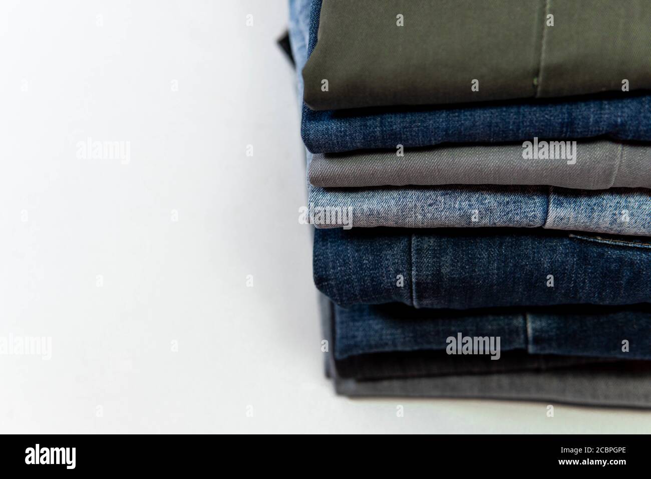 Stack of neatly folded jeans on white background Stock Photo - Alamy