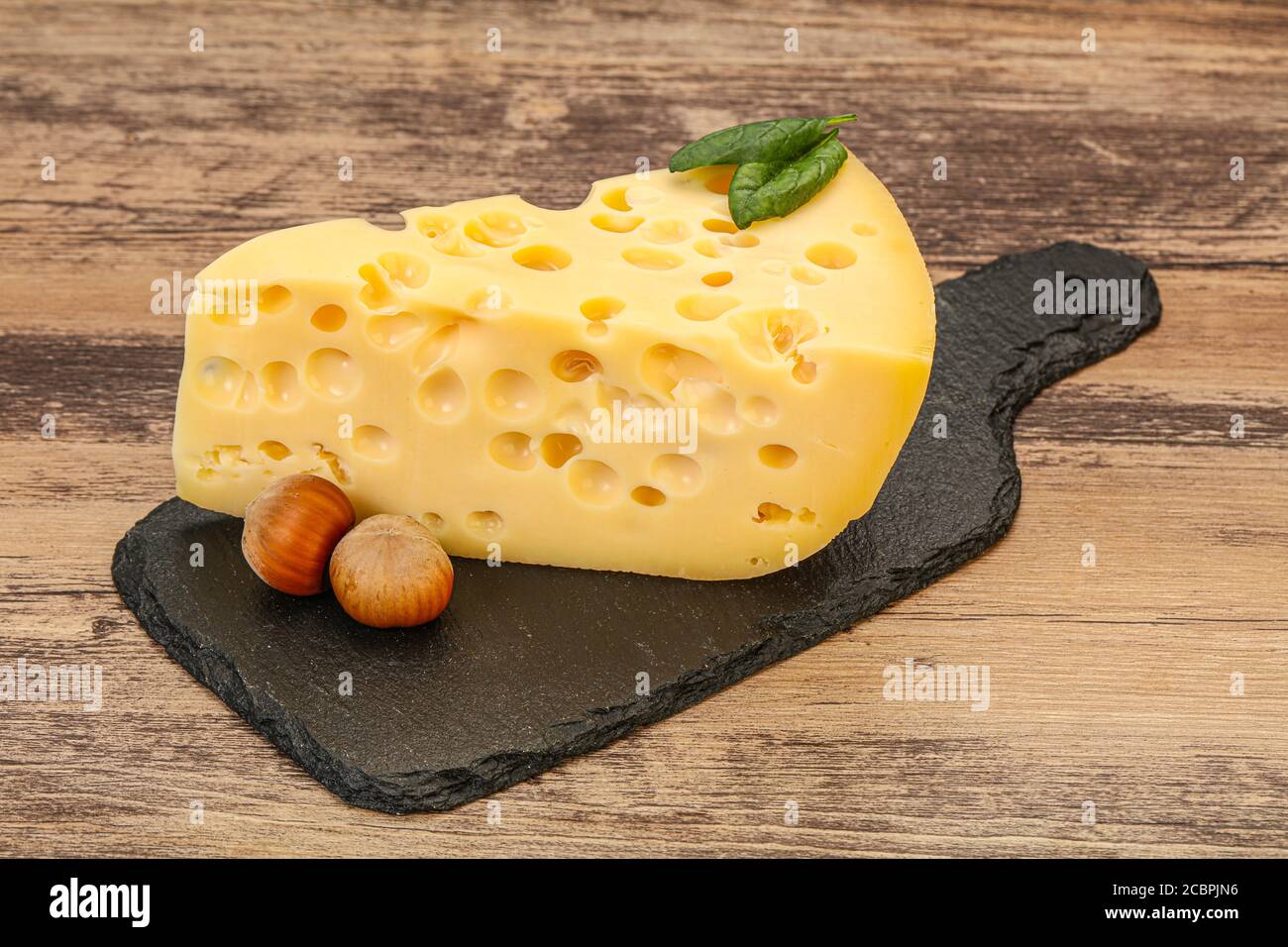 Maasdam cheese - dairy yellow triangle with holes Stock Photo - Alamy