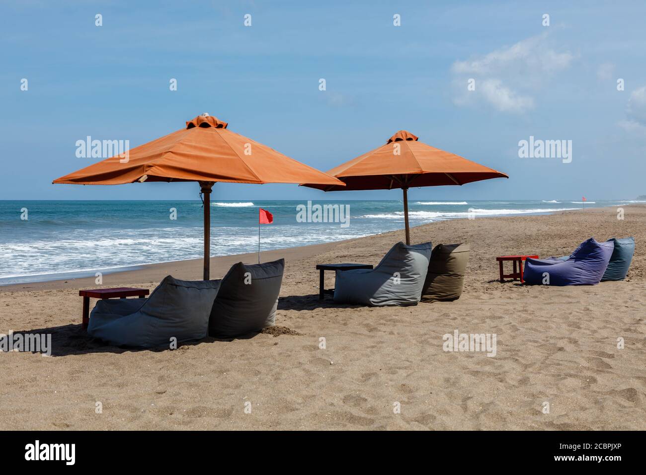 Orange sun umbrellas and empty bean bags on Berawa Beach (Pantai Berawa ...