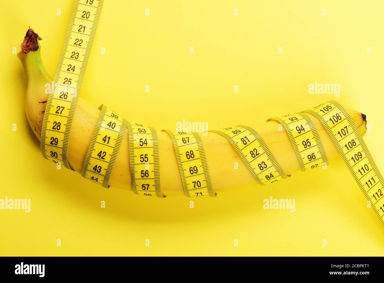 Banana with yellow tape for measuring figure. Rolled centimeter ruler ...