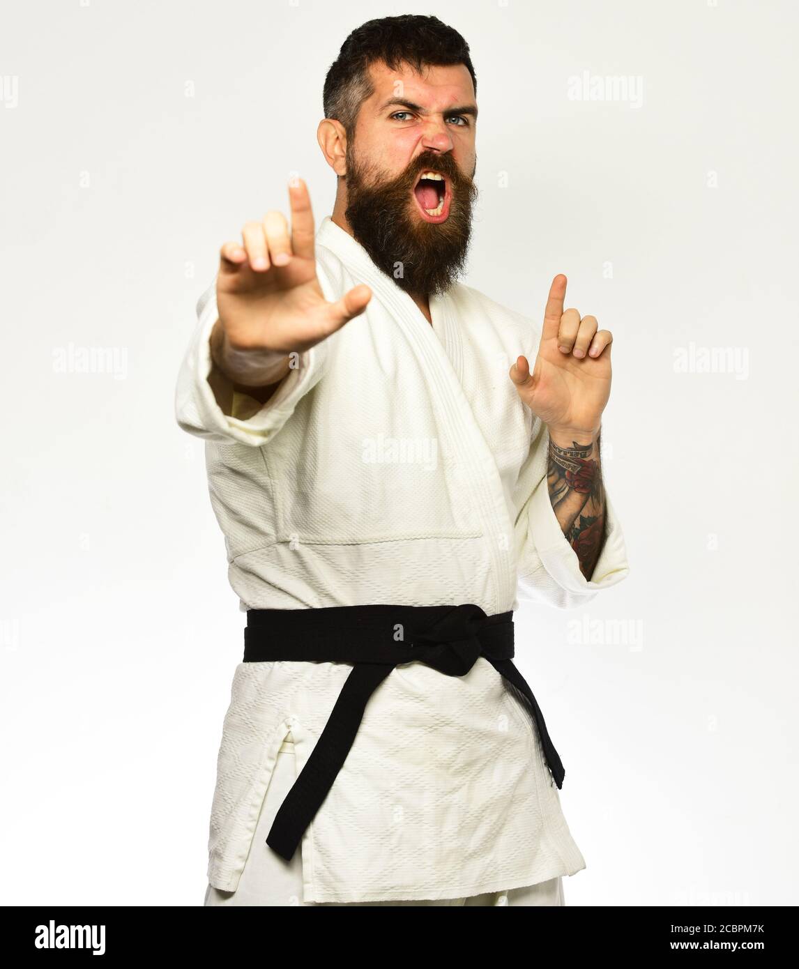 Jiu Jitsu master with black belt practices attack or defense posture ...