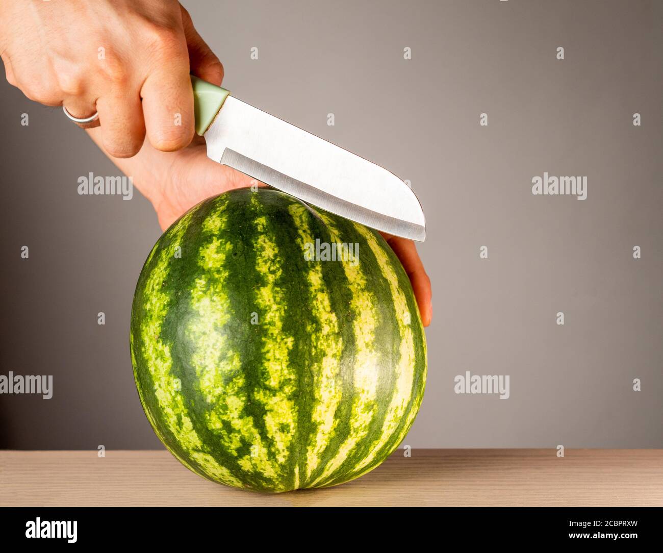 Male hand going to cut a watermelon with a knife Stock Photo - Alamy