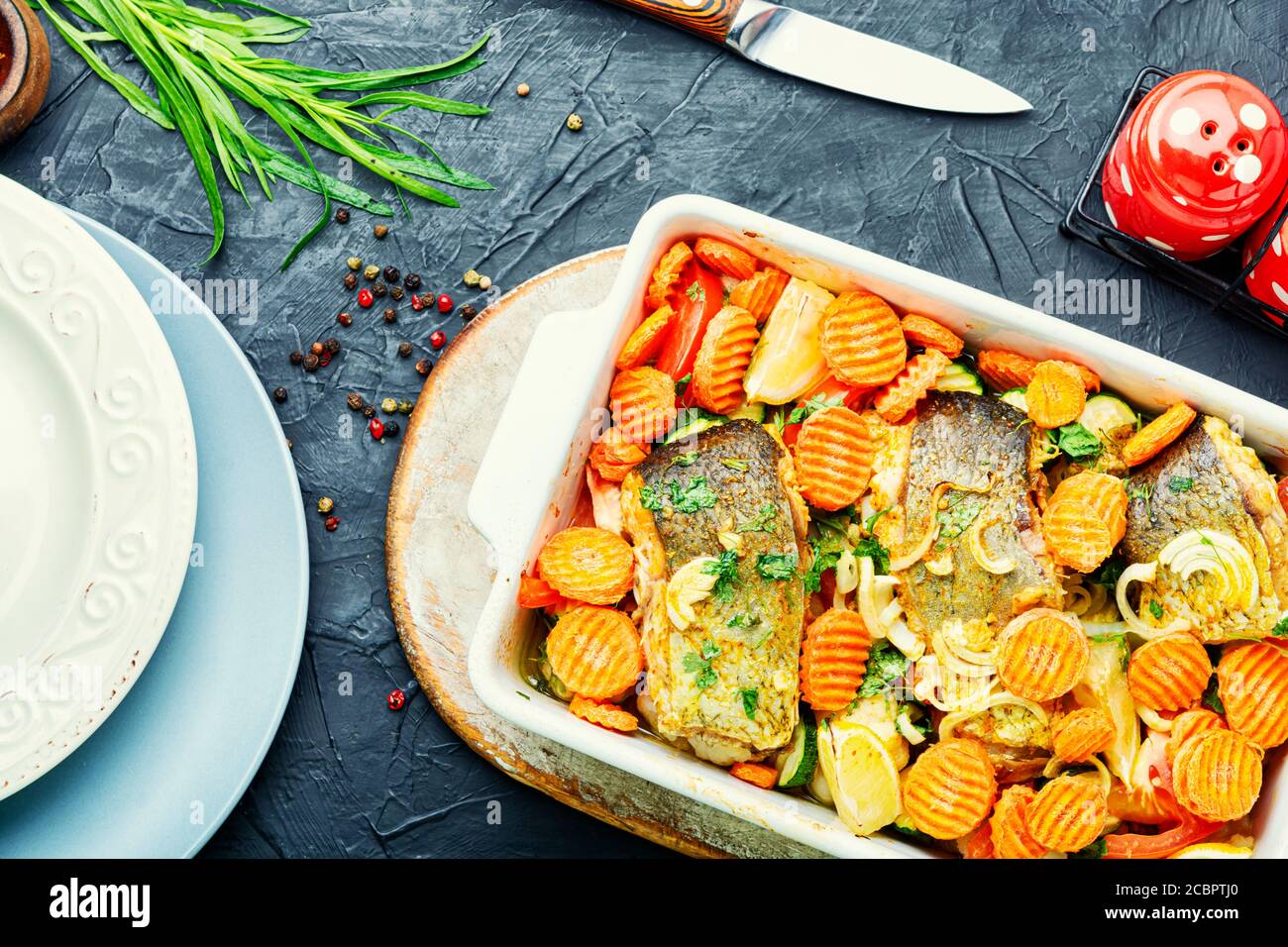 Baked fish steaks with grilled vegetables in baking dish.Delicious ...