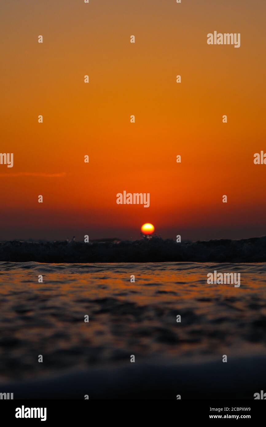 A beautiful lower angle close up view of a sunset on an ocean. With a ...