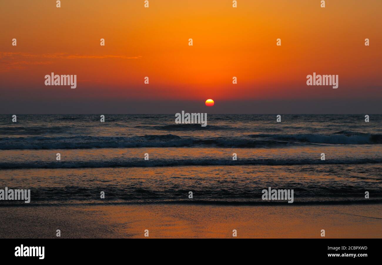 A beautiful sunset over the blue ocean with a colorful sky that ...