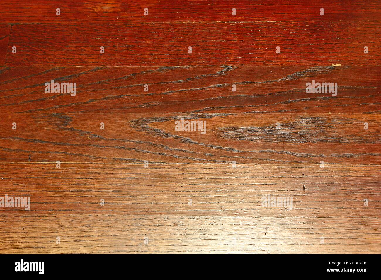 Top view of a wooden laminate flooring with scratches under the lights ...