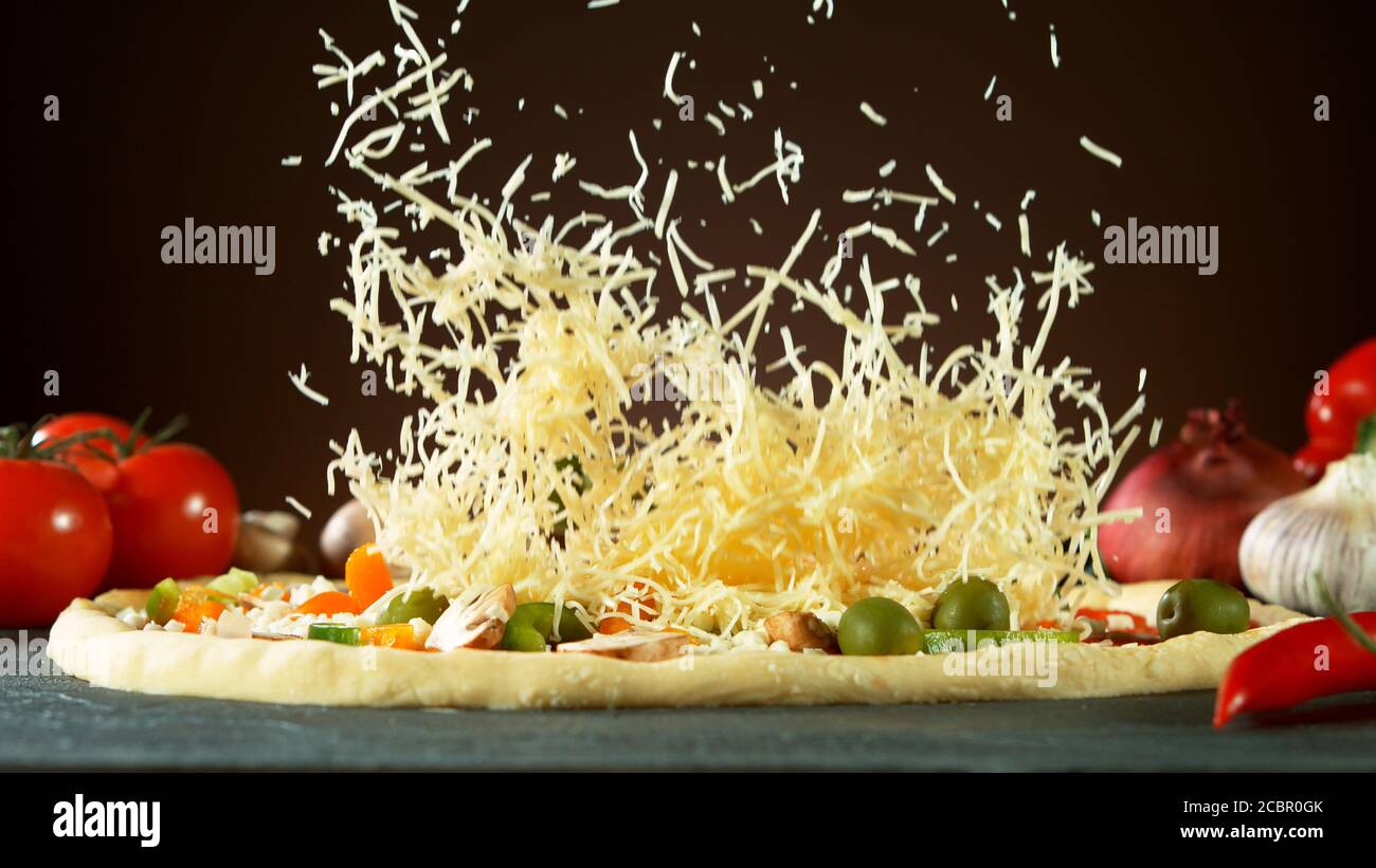 Falling mozzarella cheese on pizza, freeze motion. Italian traditional ...