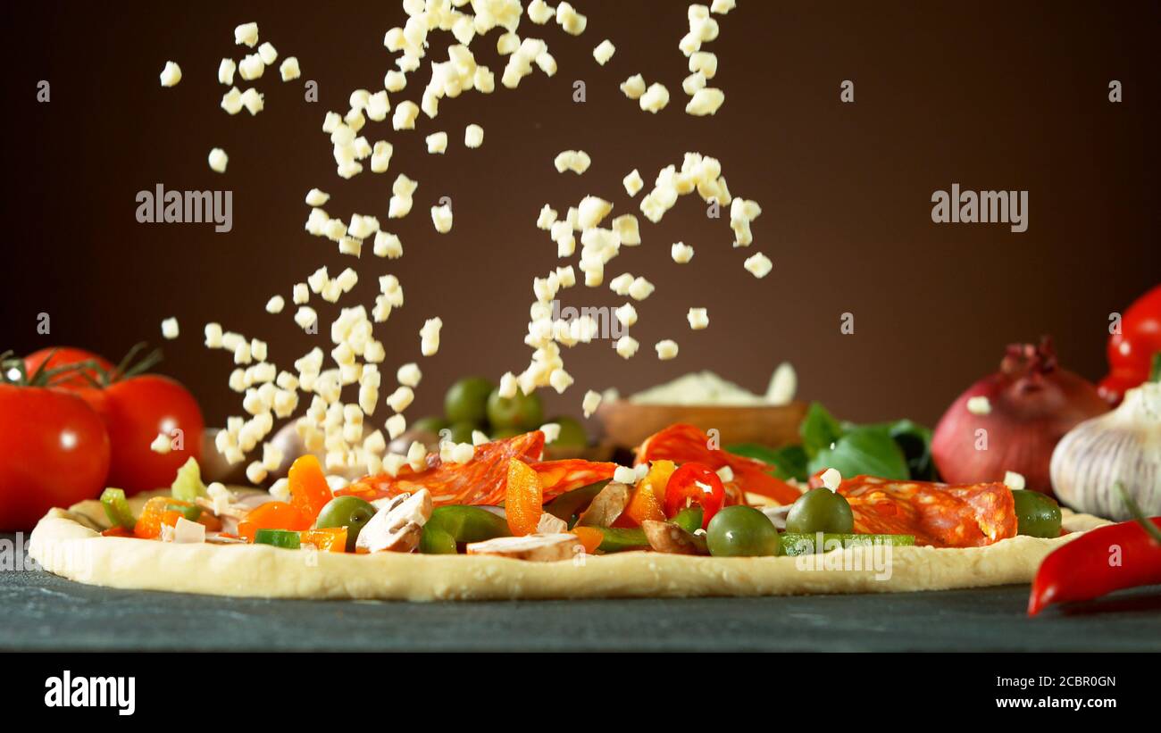 Falling mozzarella cheese on pizza, freeze motion. Italian traditional ...