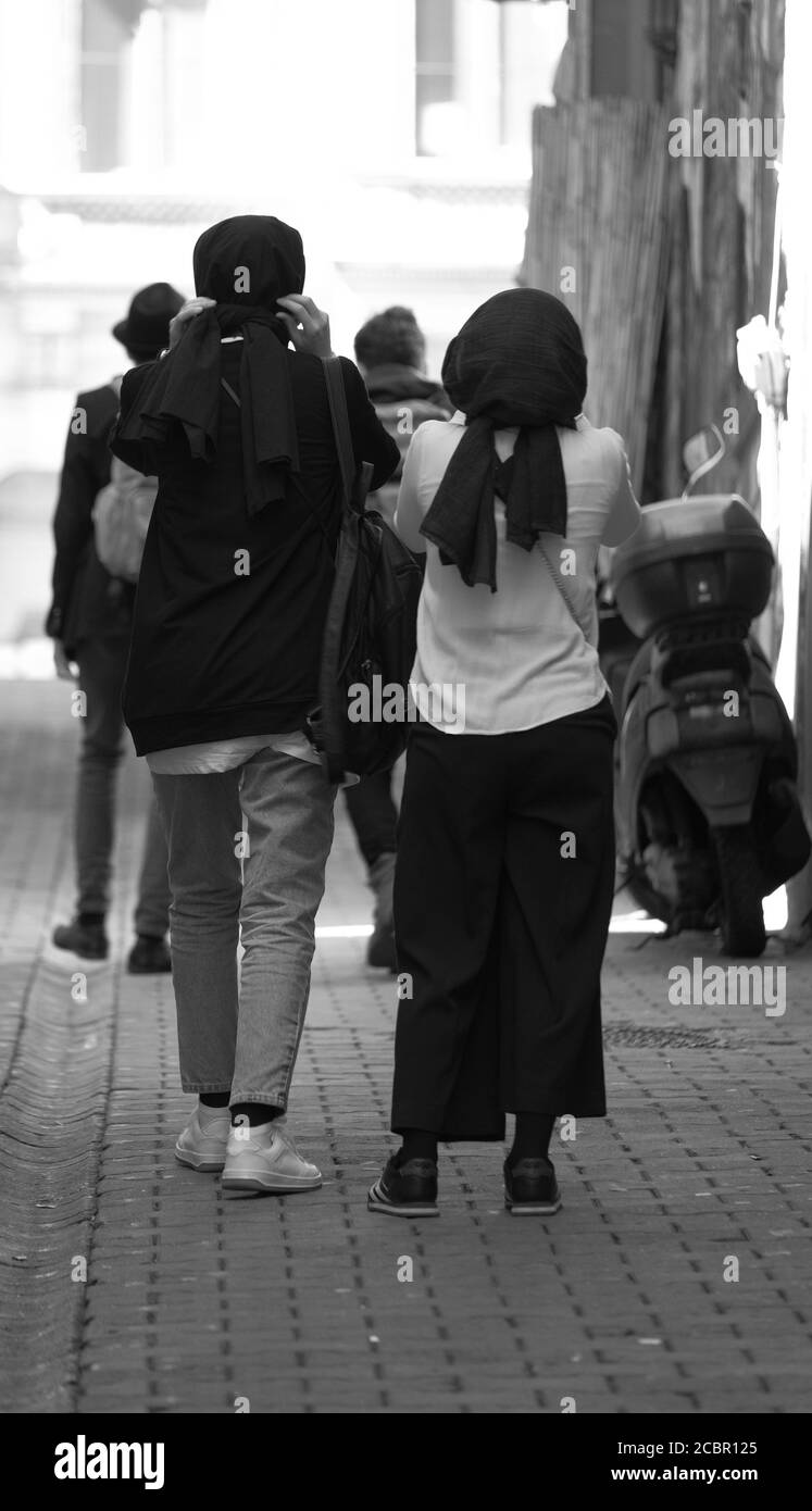 Vertical greyscale shot of Muslim people walking in the street Stock ...