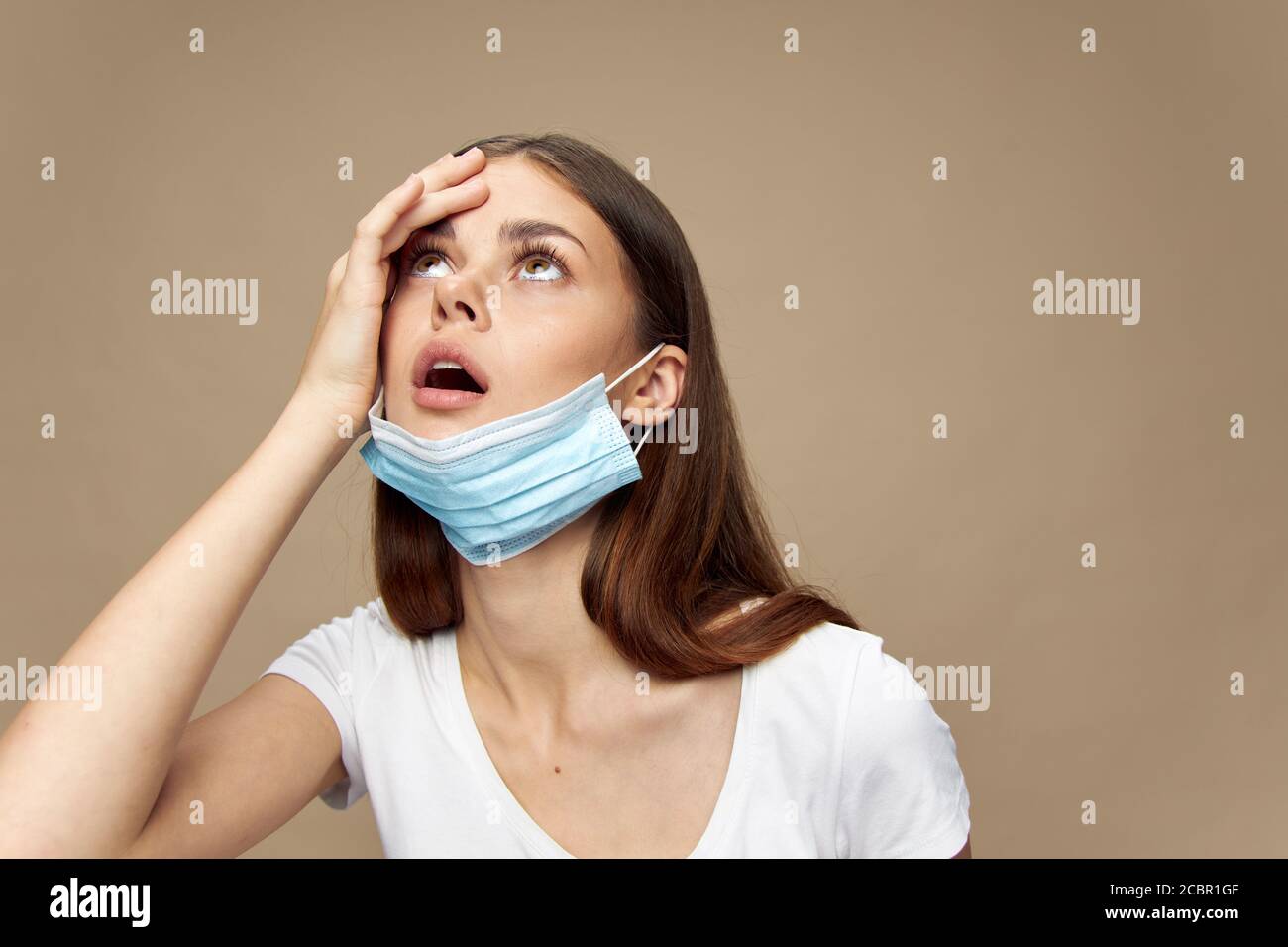 Woman with a medical mask on her ears wide open mouth and hand Stock ...