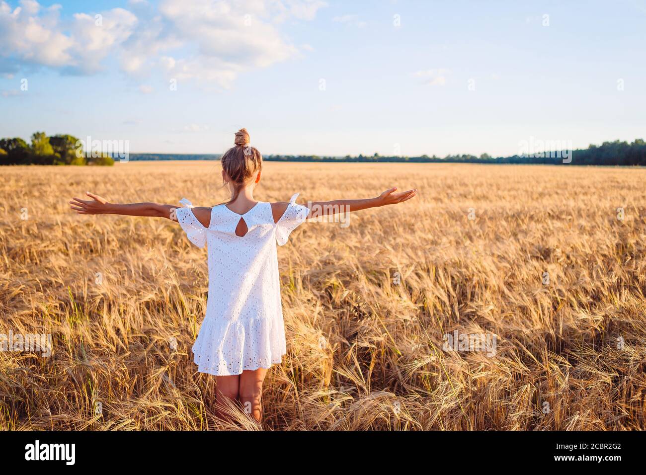 Happy cute girl in wheat field outdoors Stock Photo - Alamy
