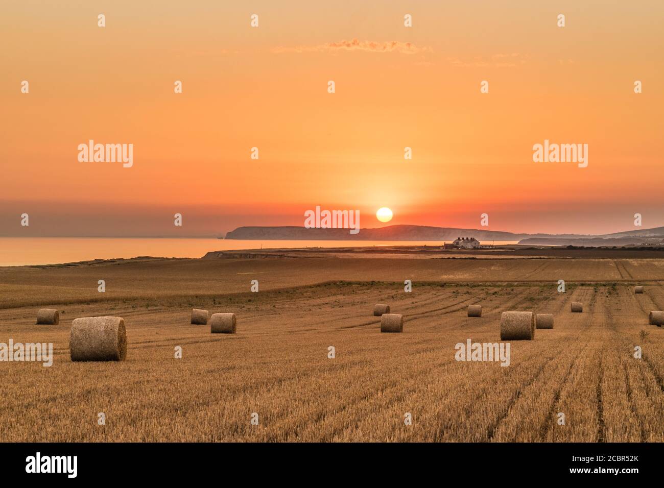 West Wight sunset in field of round bales Stock Photo - Alamy