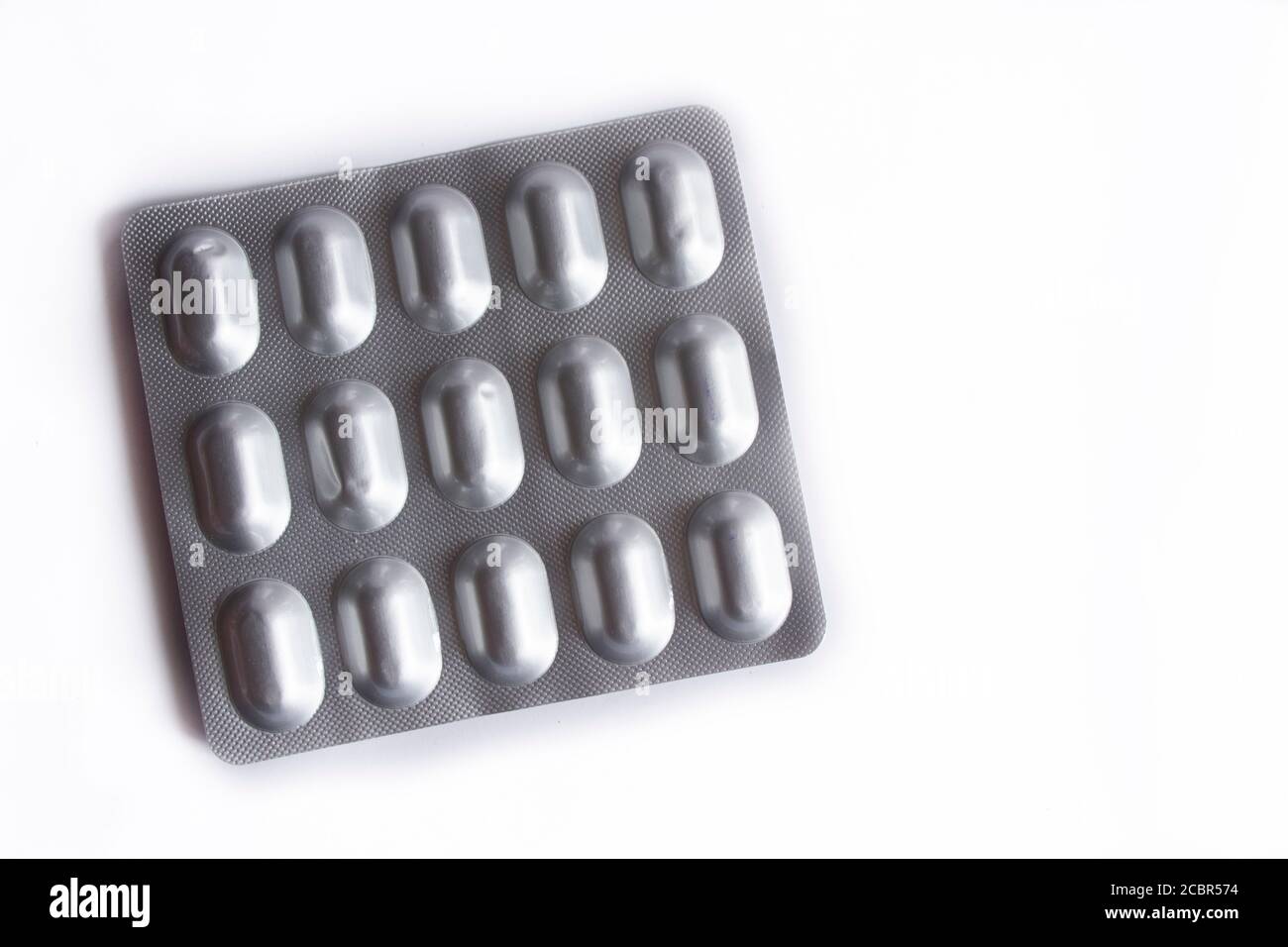 Pills in silver packaging on white background Stock Photo - Alamy