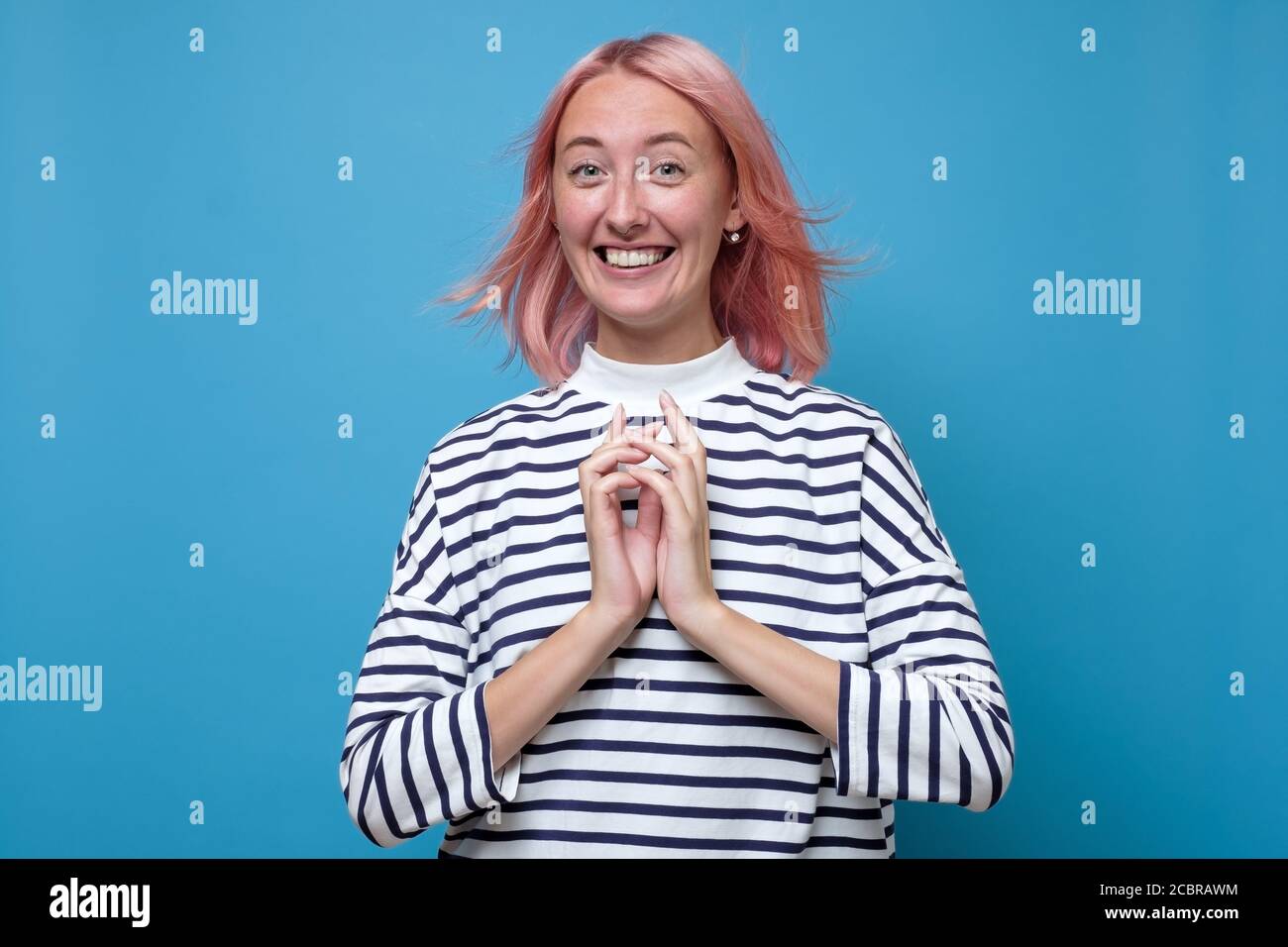 Sly caucasian woman with dyed pink hair planning prank or evil trick ...