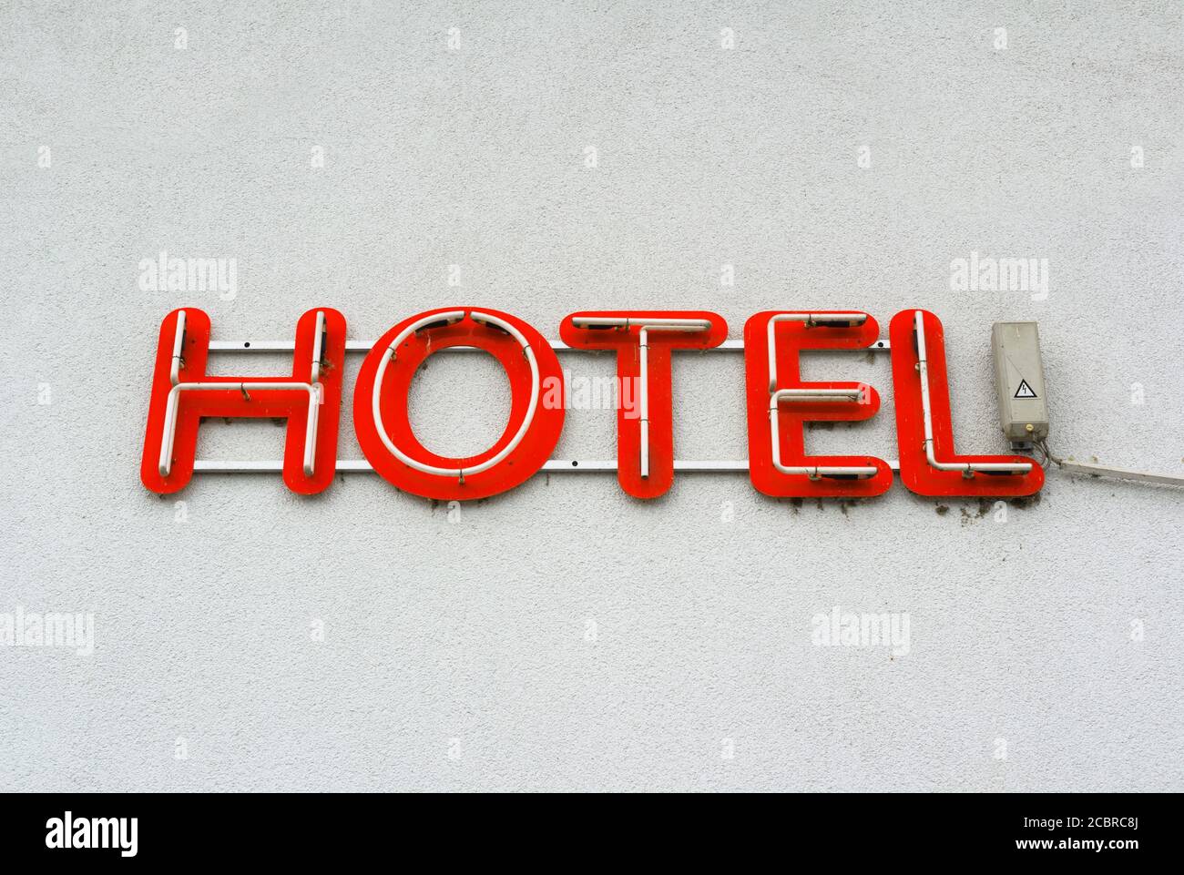 Hotel sign - uncovered neon tube on the white wall. Advertising for ...