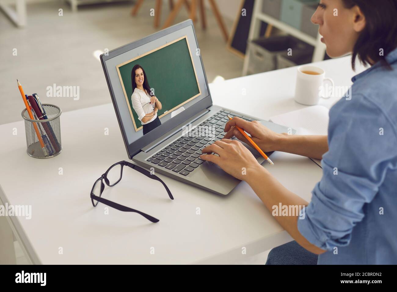 Young woman at home with laptop uses video call and studies online ...