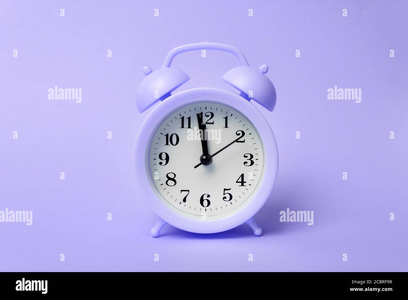 Top view of classic alarm clock on purple background. Time concept ...