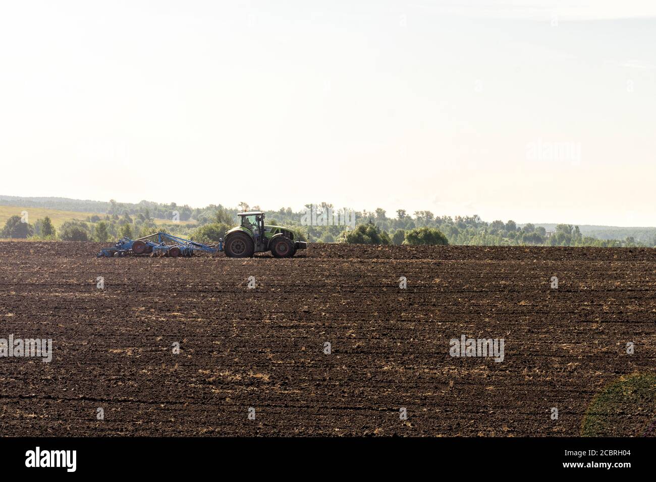 tractor plows agricultural field. work in the field with a tractor ...