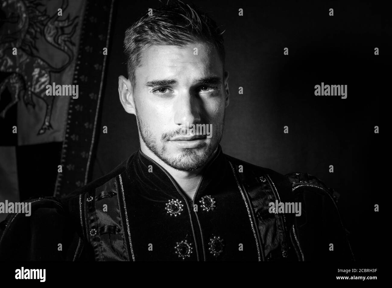 Portrait of attractive king with beard dressed in costume looking at ...