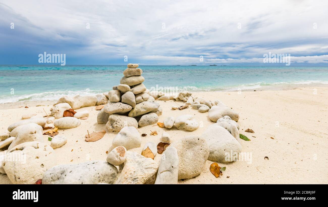 Stacked stones over the sea at sunset. Balanced stones stacked to a ...