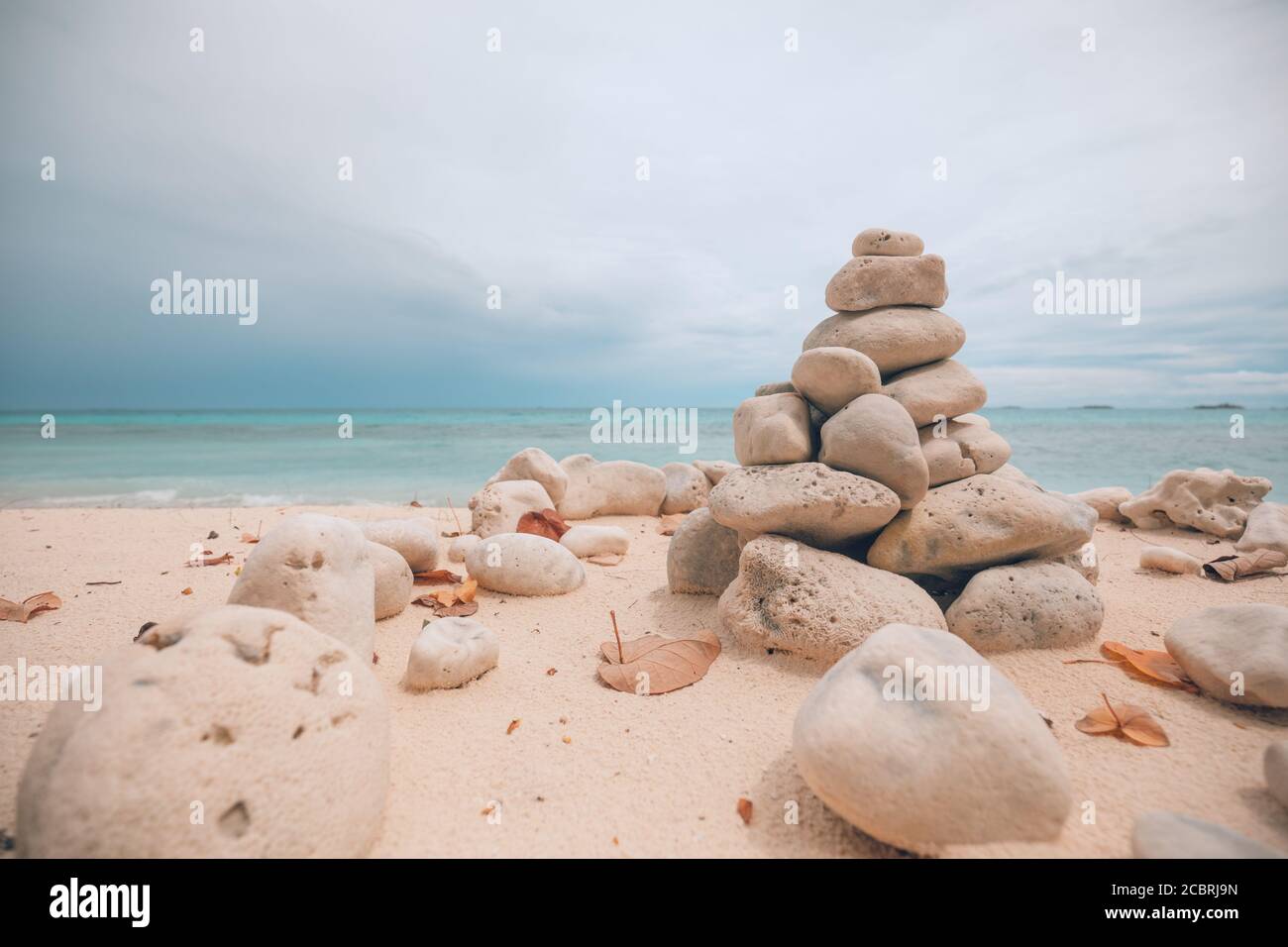 Stacked stones over the sea at sunset. Balanced stones stacked to a ...