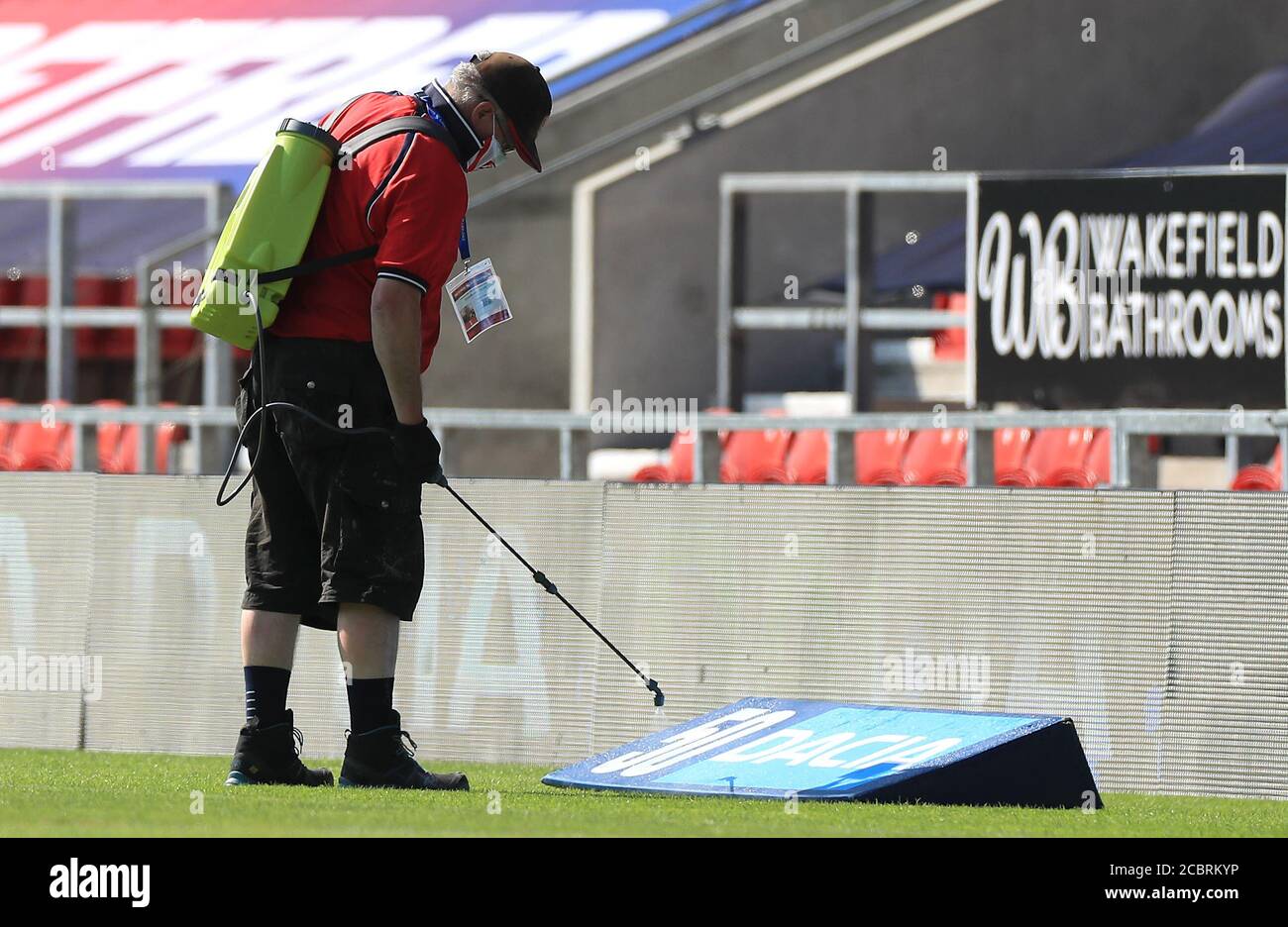 A ground staff member disinfects the area around the pitch before the ...