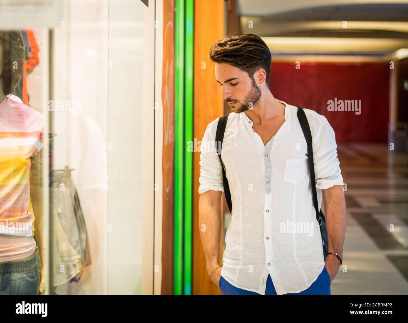 Young Man Looking at Fashion Items in Shop Window Stock Photo - Alamy