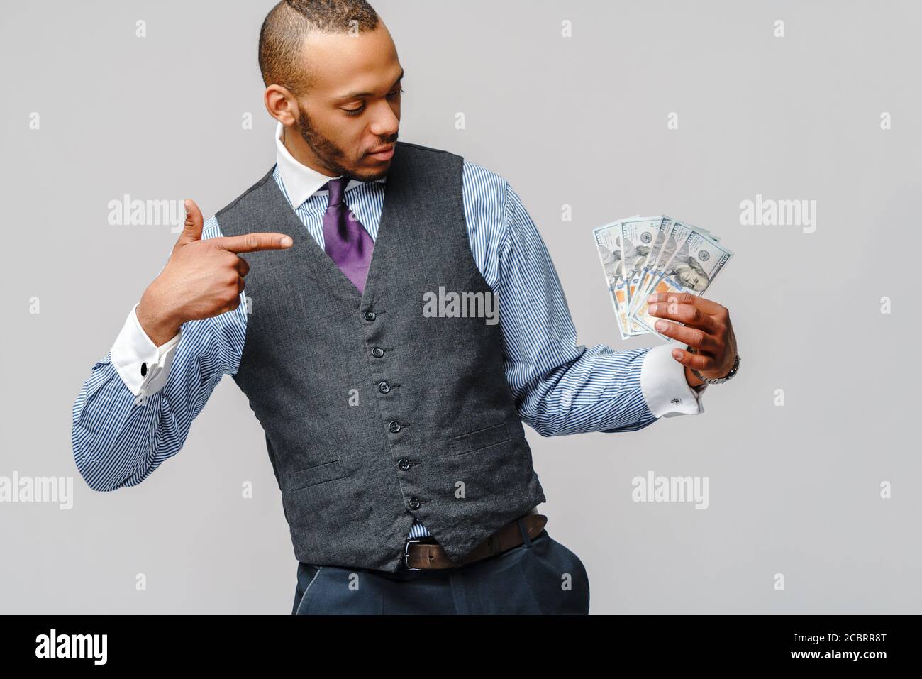 Portrait of excited young african american man holding cash money and ...
