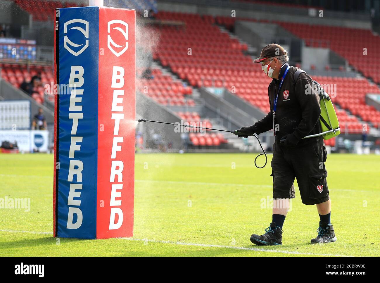 A ground staff member disinfects the posts during the half-time during ...