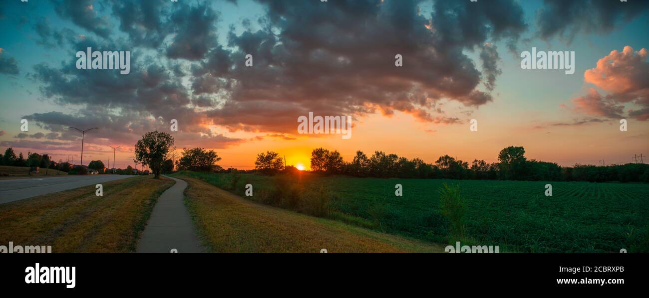 Sunset over field and trail Stock Photo - Alamy