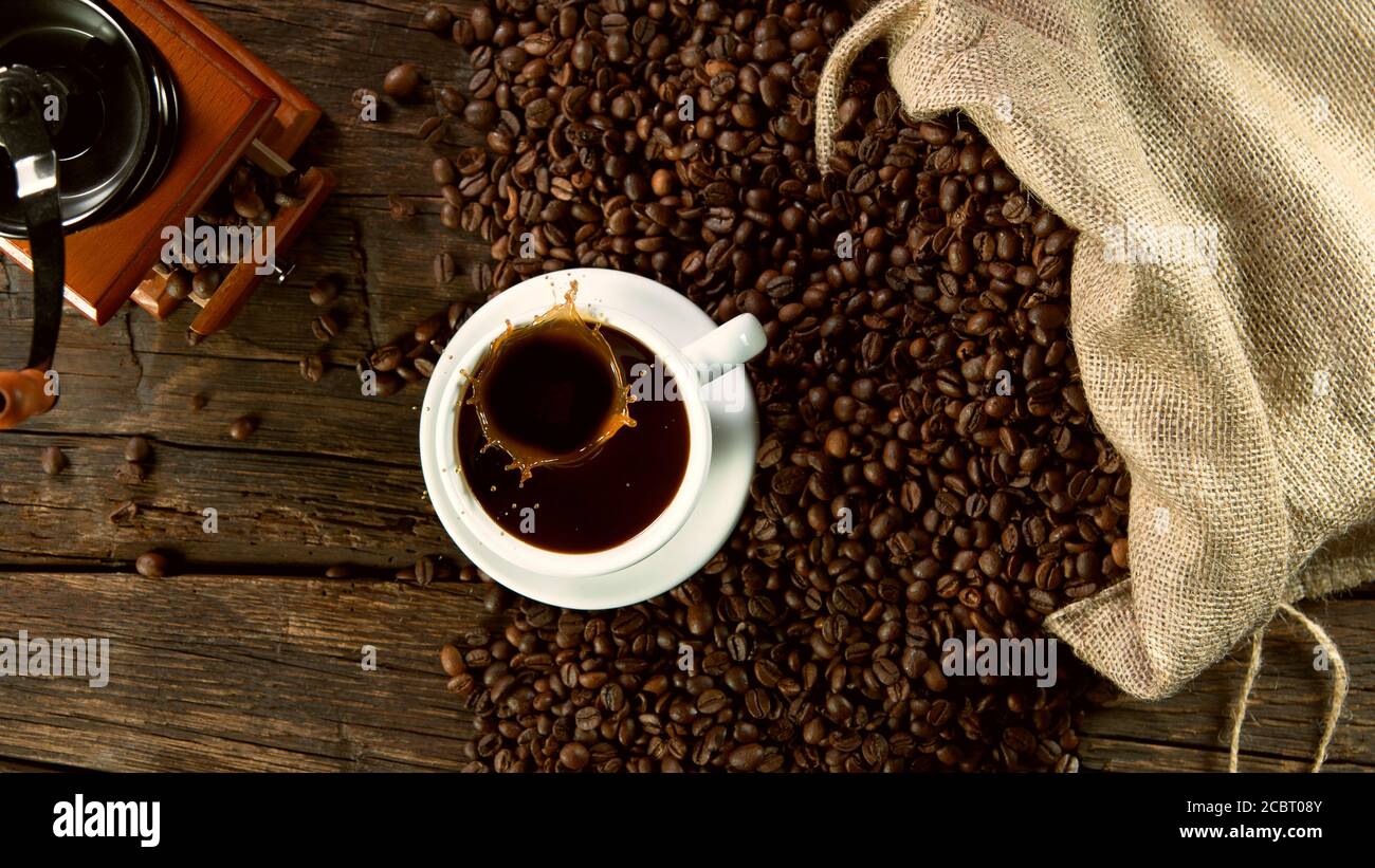 Falling sugar canes into cup of hot coffee, high angle of view. Still ...