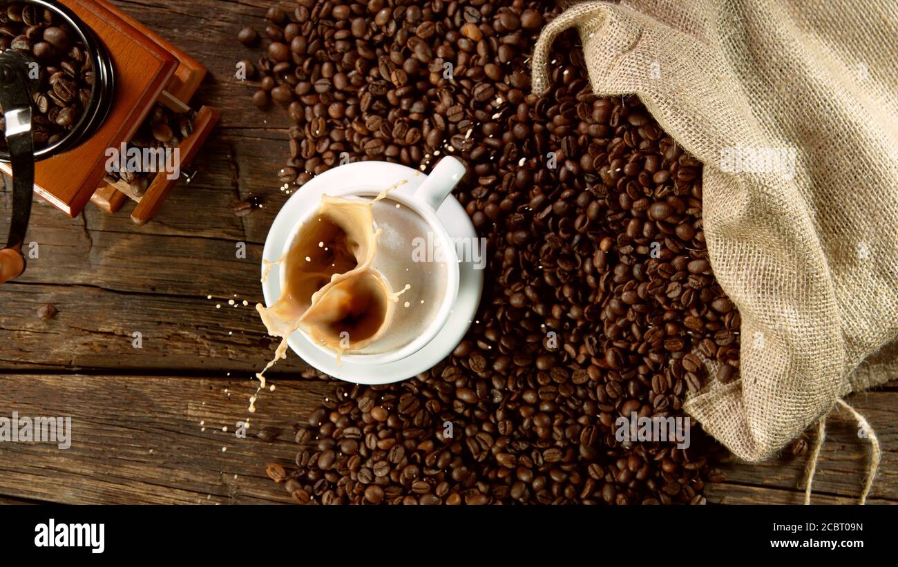 Falling sugar canes into cup of hot coffee, high angle of view. Still ...