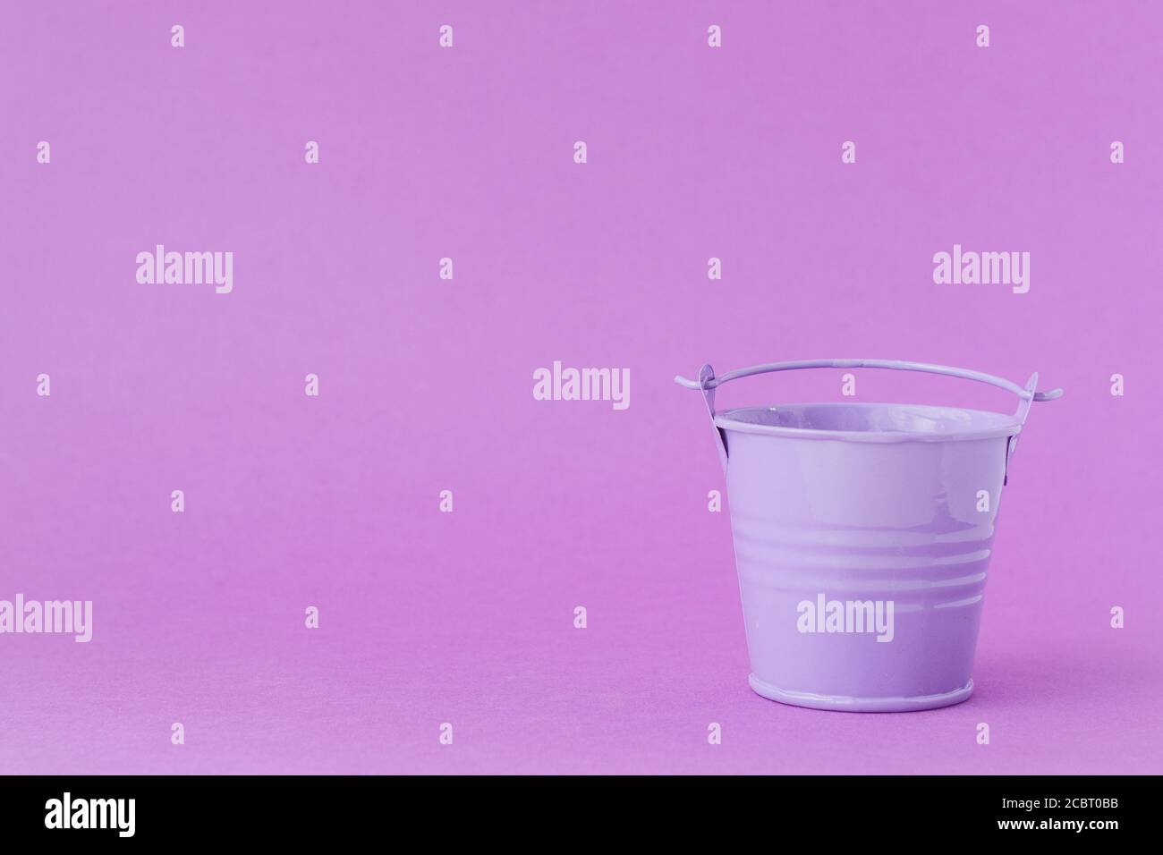Toy iron bucket light purple on a dark purple background. Place for ...