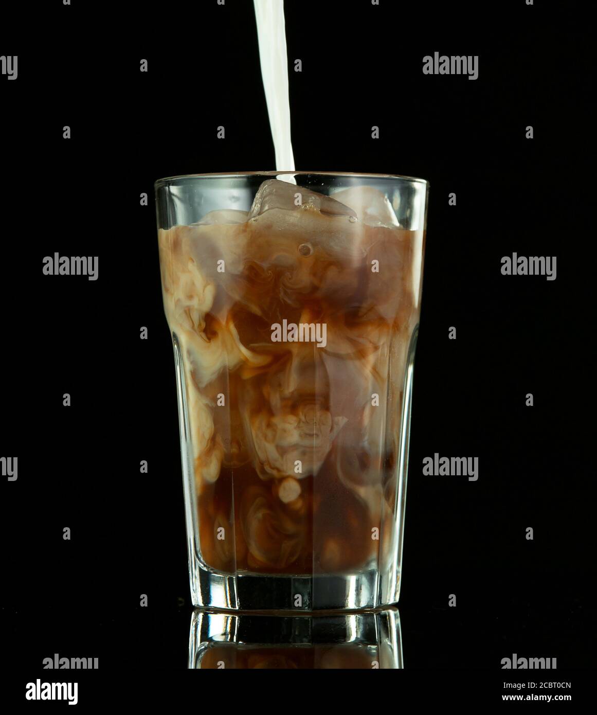 Pouring ice coffee drink on black background. Freeze motion of fresh ...