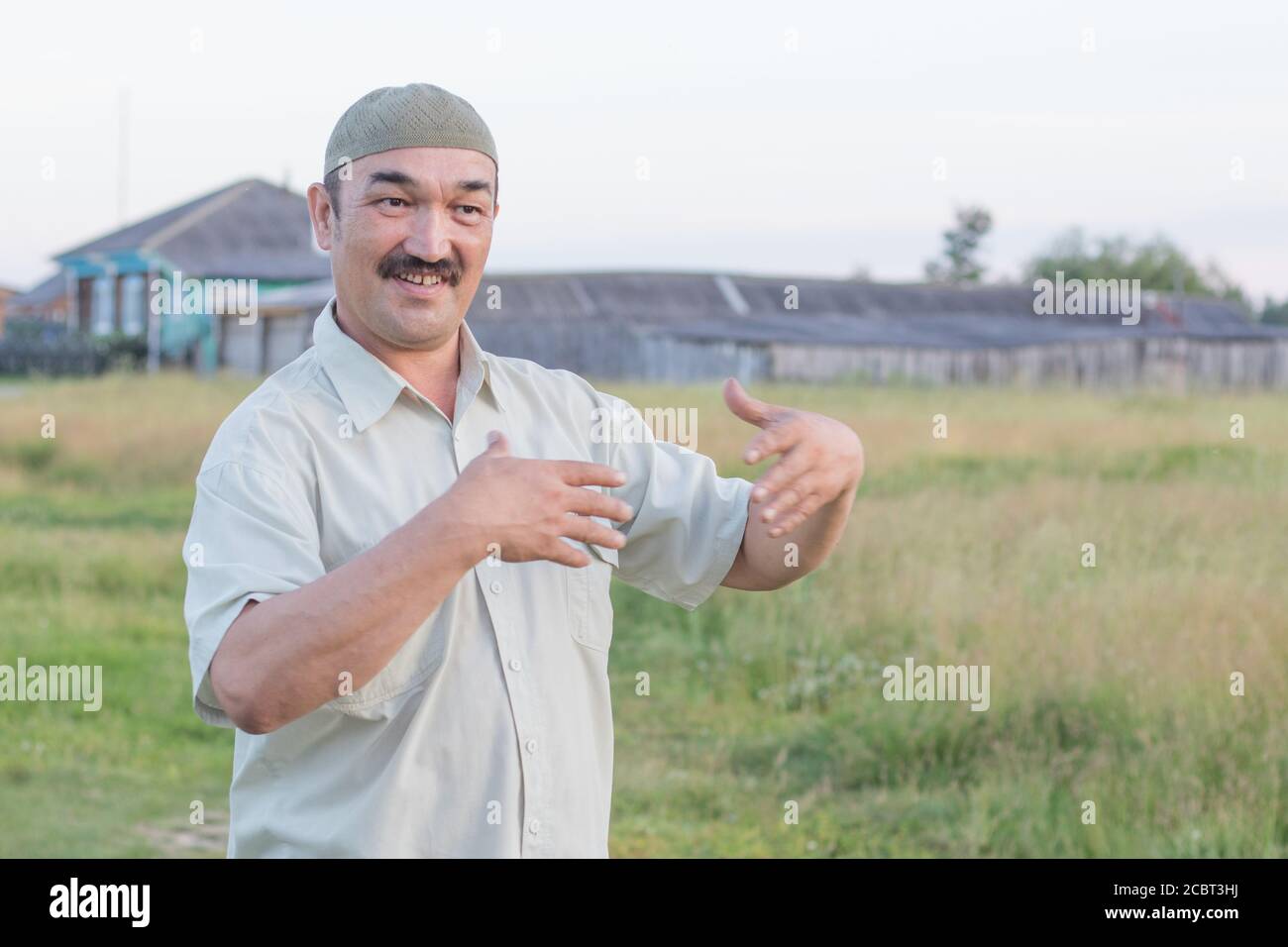 Muslim senior man stands and talks about something funny against the ...