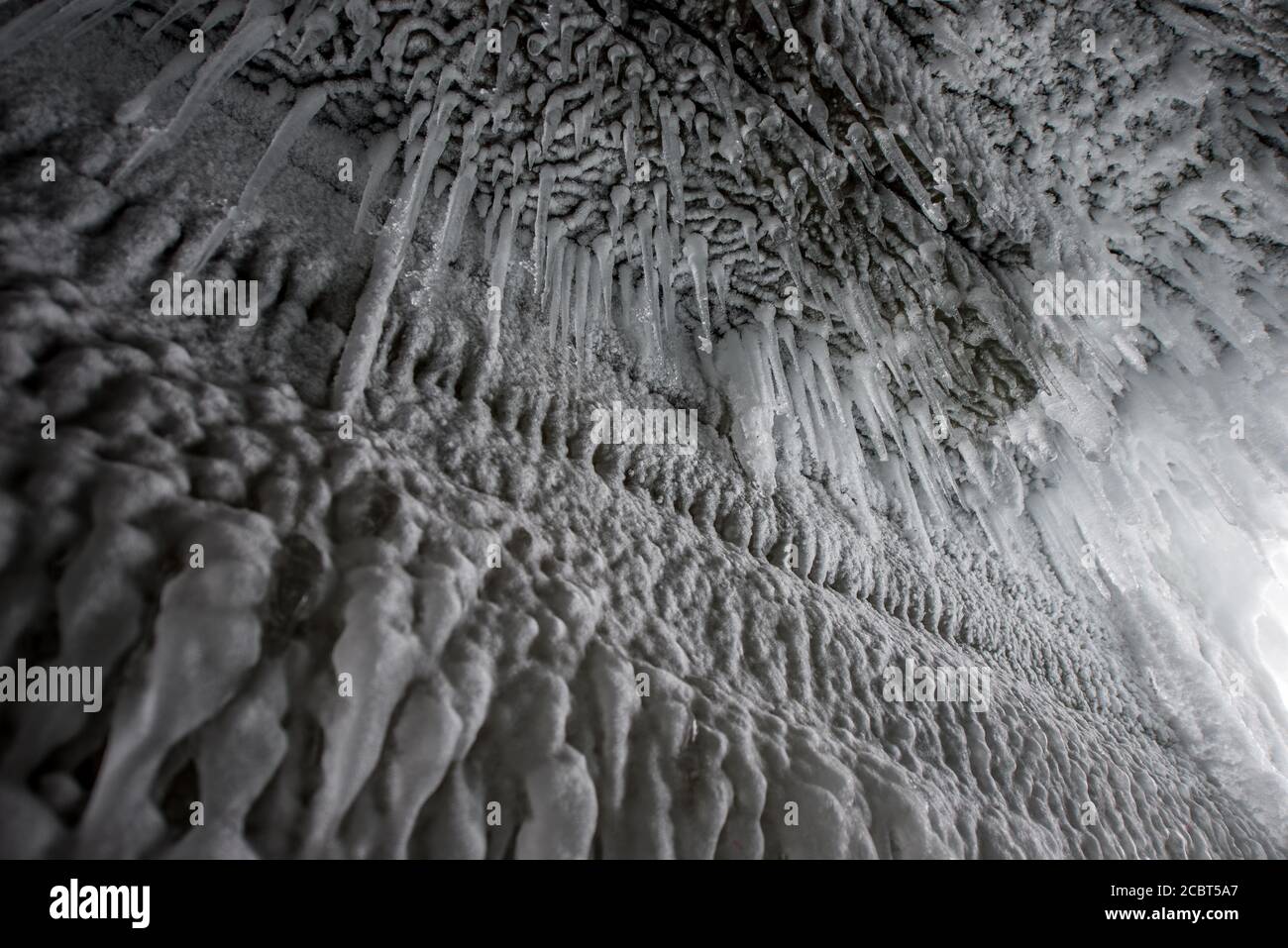 Ice stalactites hanging from the ceiling of an ice cave on Olkhon ...