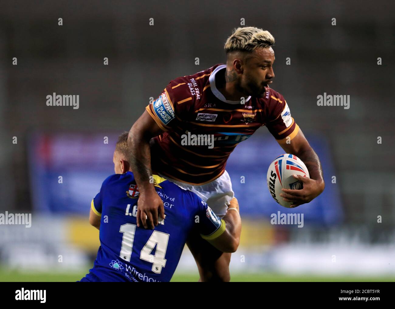 Huddersfield Giants' Kenny Edwards is tackled by Warrington Wolves ...
