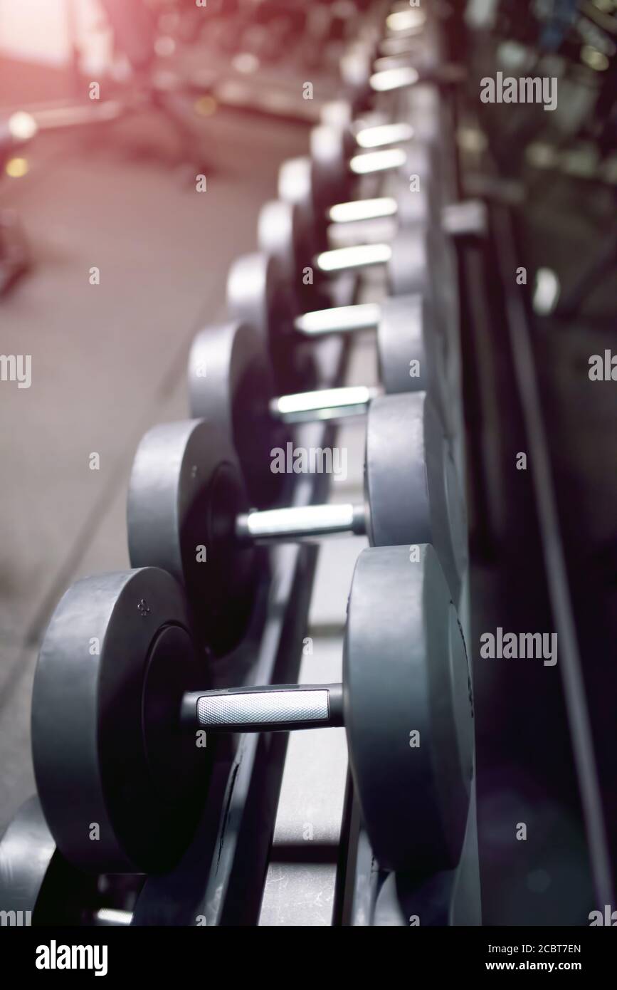 Detail of a dumbbells stand in a gym, flare effect Stock Photo - Alamy