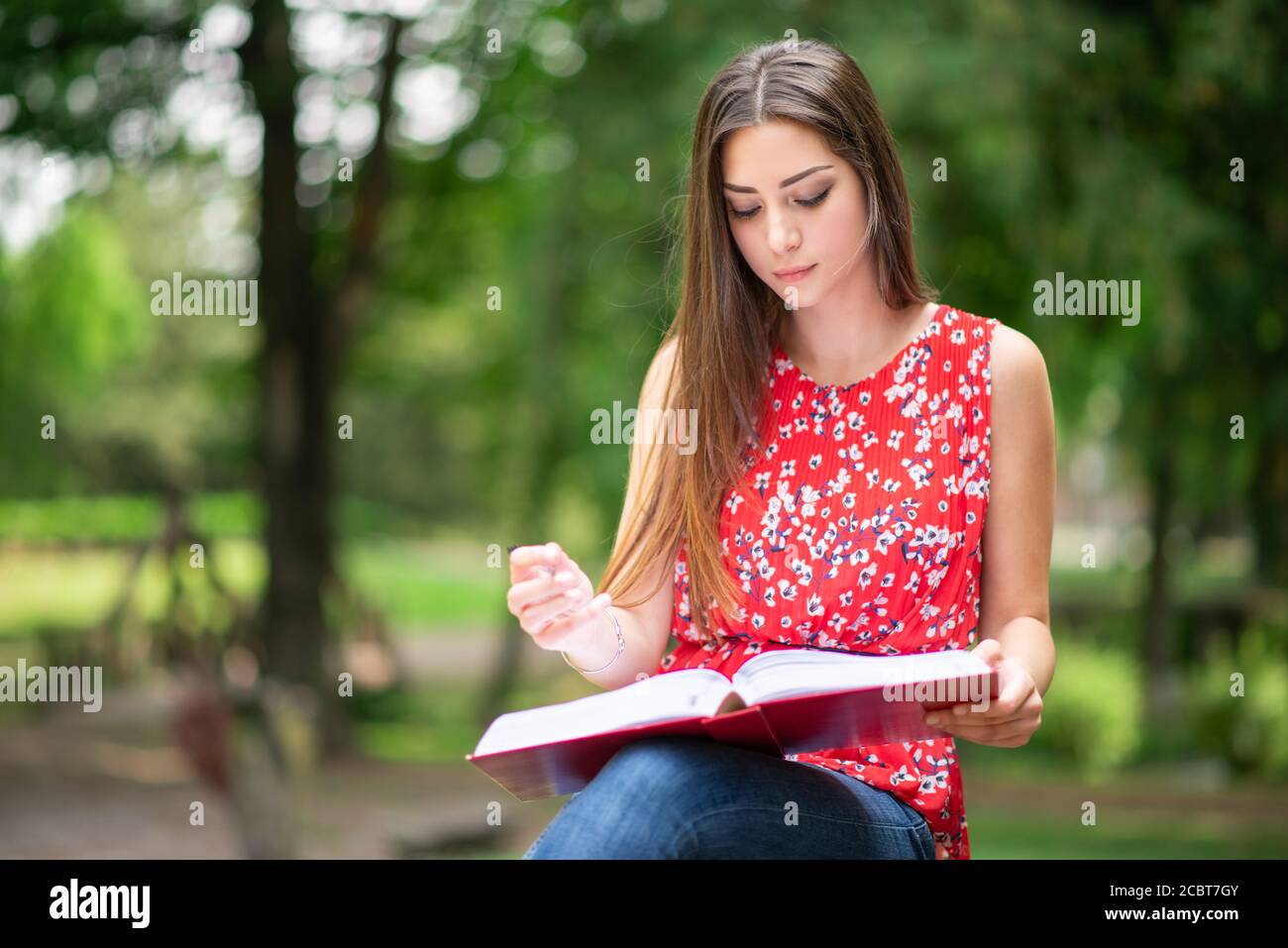 Woman reading a book while taking notes hi-res stock photography and ...